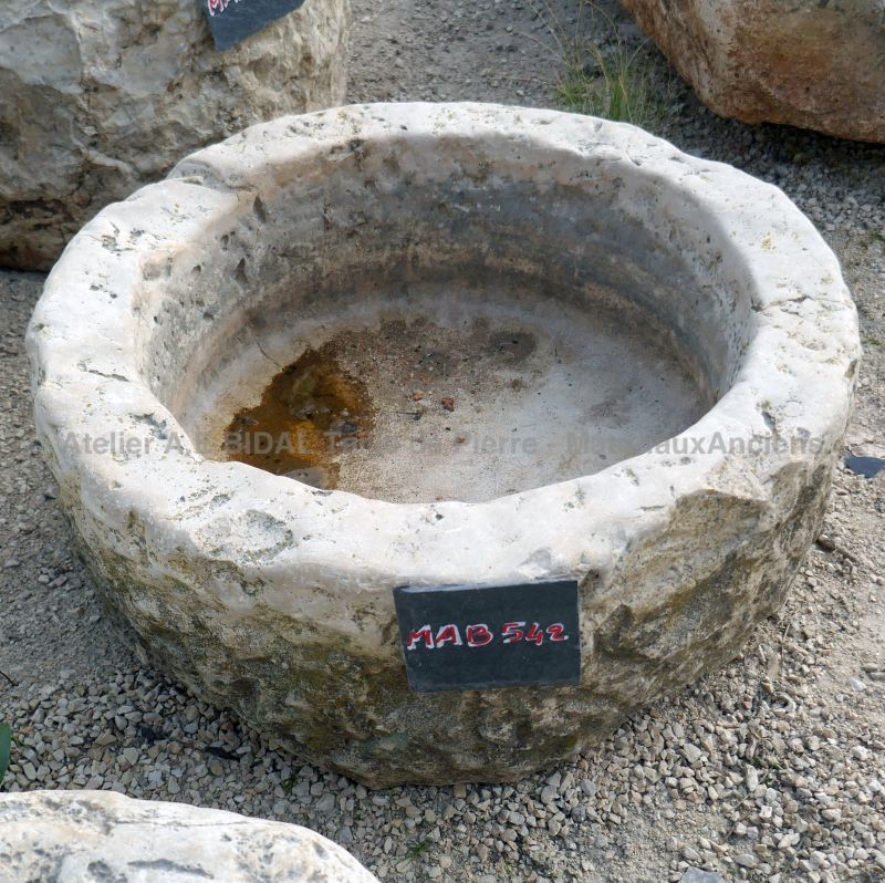 Old round-shaped trough as a small flower box made of hard stone
