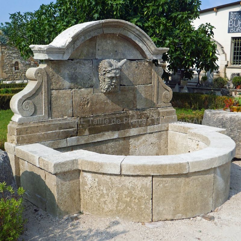 Wall fountain with rounded basin in old stones : large garden fountain