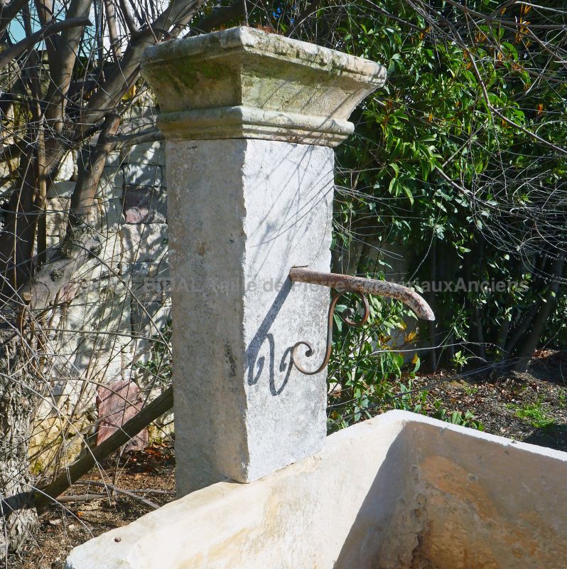 Fontaine rustique de Provence avec large bac ancien et étroit fronton