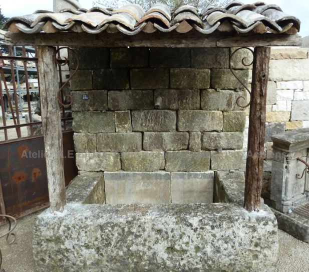 Antique stone well fountain with antique arbor tiles