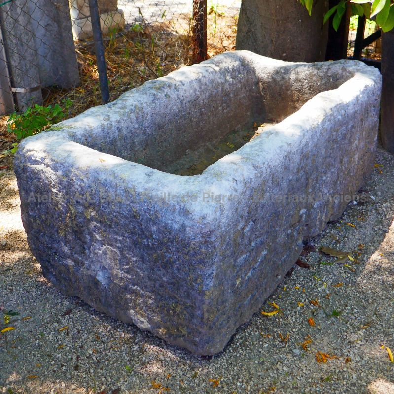 Old stone trough : a long antique garden trough in patinated stone