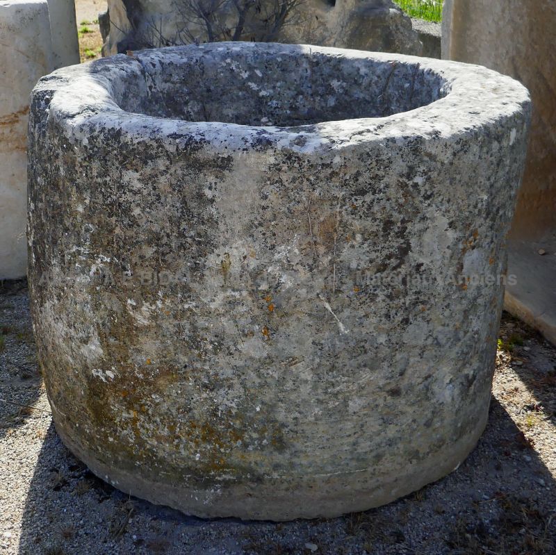 Large rustic well in aged and patinated stone for outdoor decoration