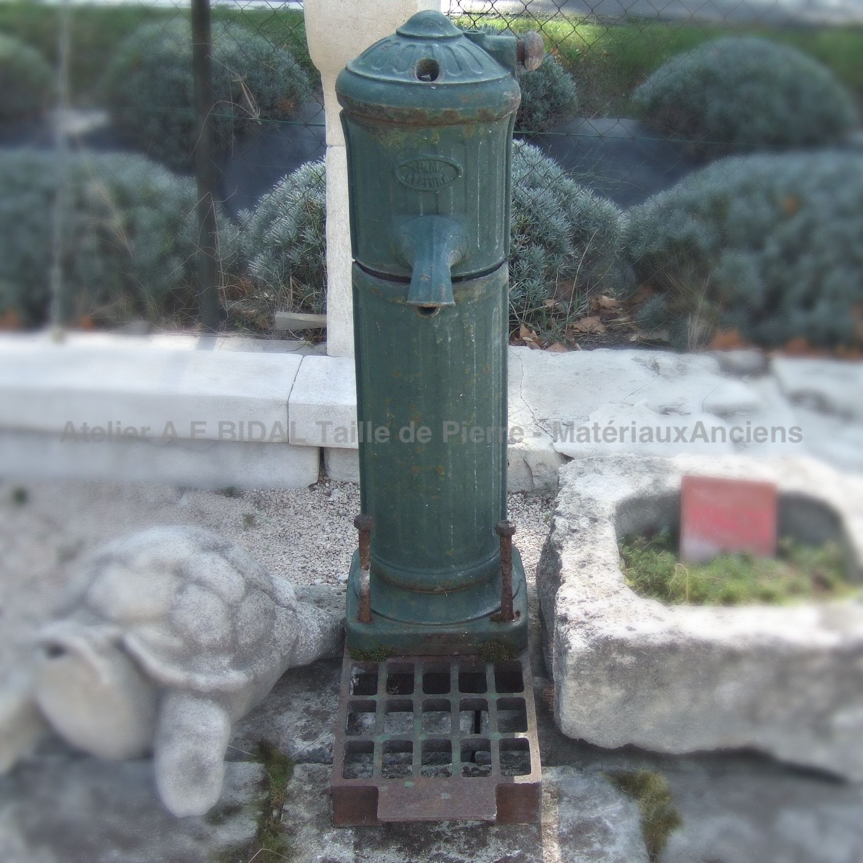 Pompe manuelle en fonte ancienne - une pompe à eau à la couleur verte.