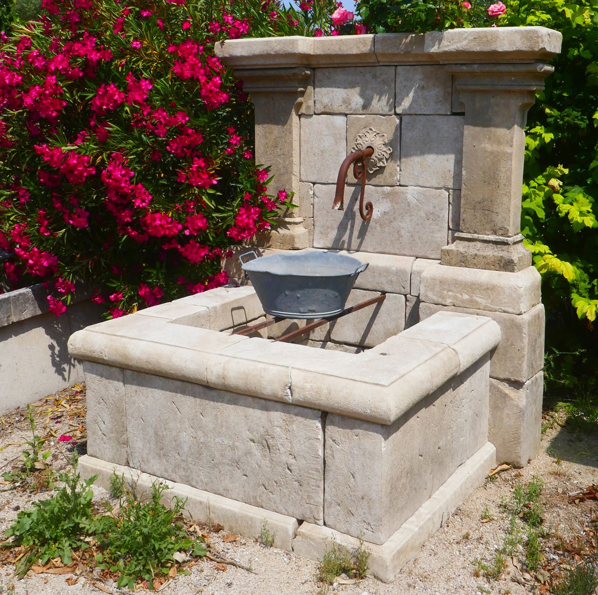 Outdoor fountain with basin and pediment with 2 columns and a rosace
