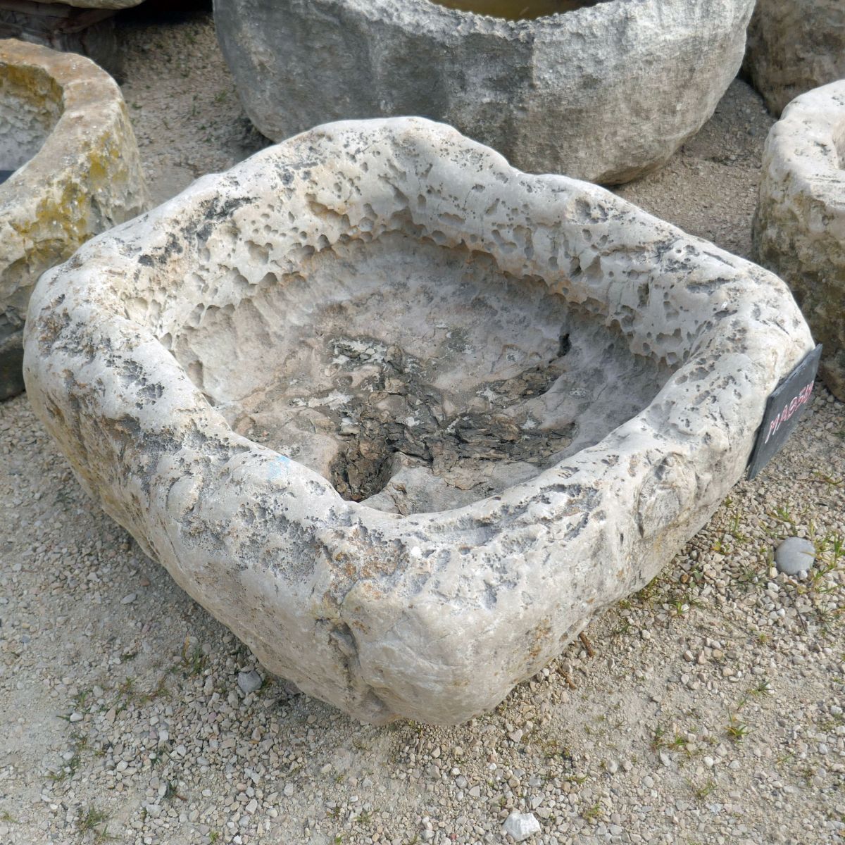 Small rustic trough in weathered stone : old monolithic trough