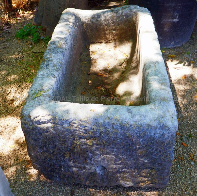 Old stone trough : a long antique garden trough in patinated stone